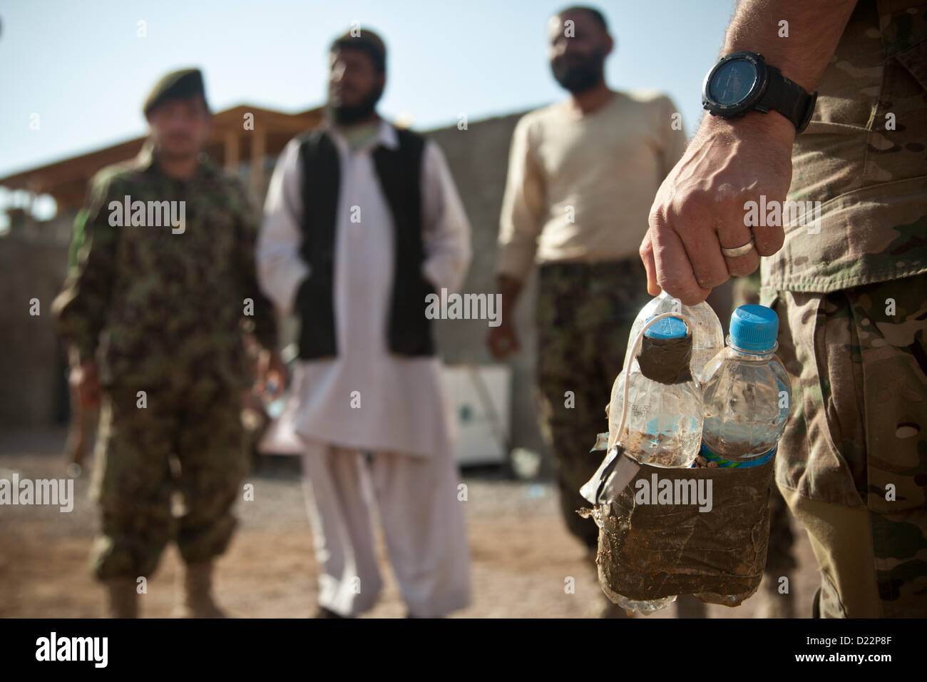 A coalition forces member demonstrates handling a simulated improvised ...
