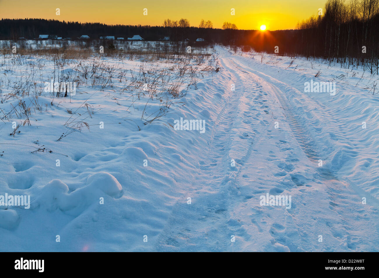 sunset under dark blue winter snowy country road Stock Photo - Alamy