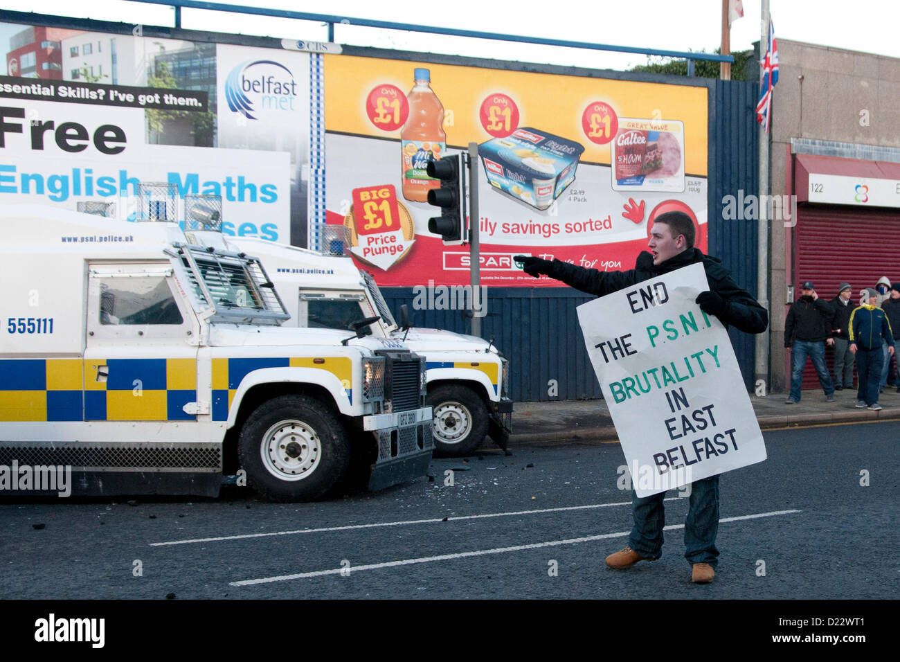 Belfast, UK. 12/01/13. A man holding a placard shouts at police as ...