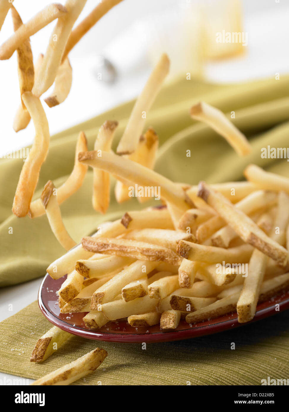 French fries falling on plate Stock Photo - Alamy