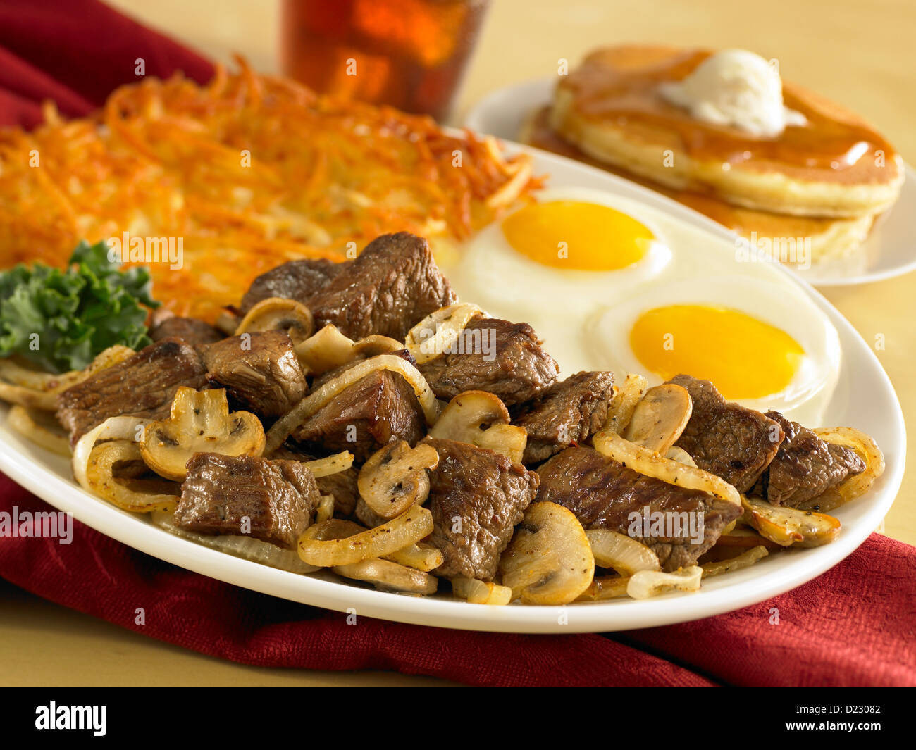 Steak and egg breakfast served with pancakes and hash browns Stock ...