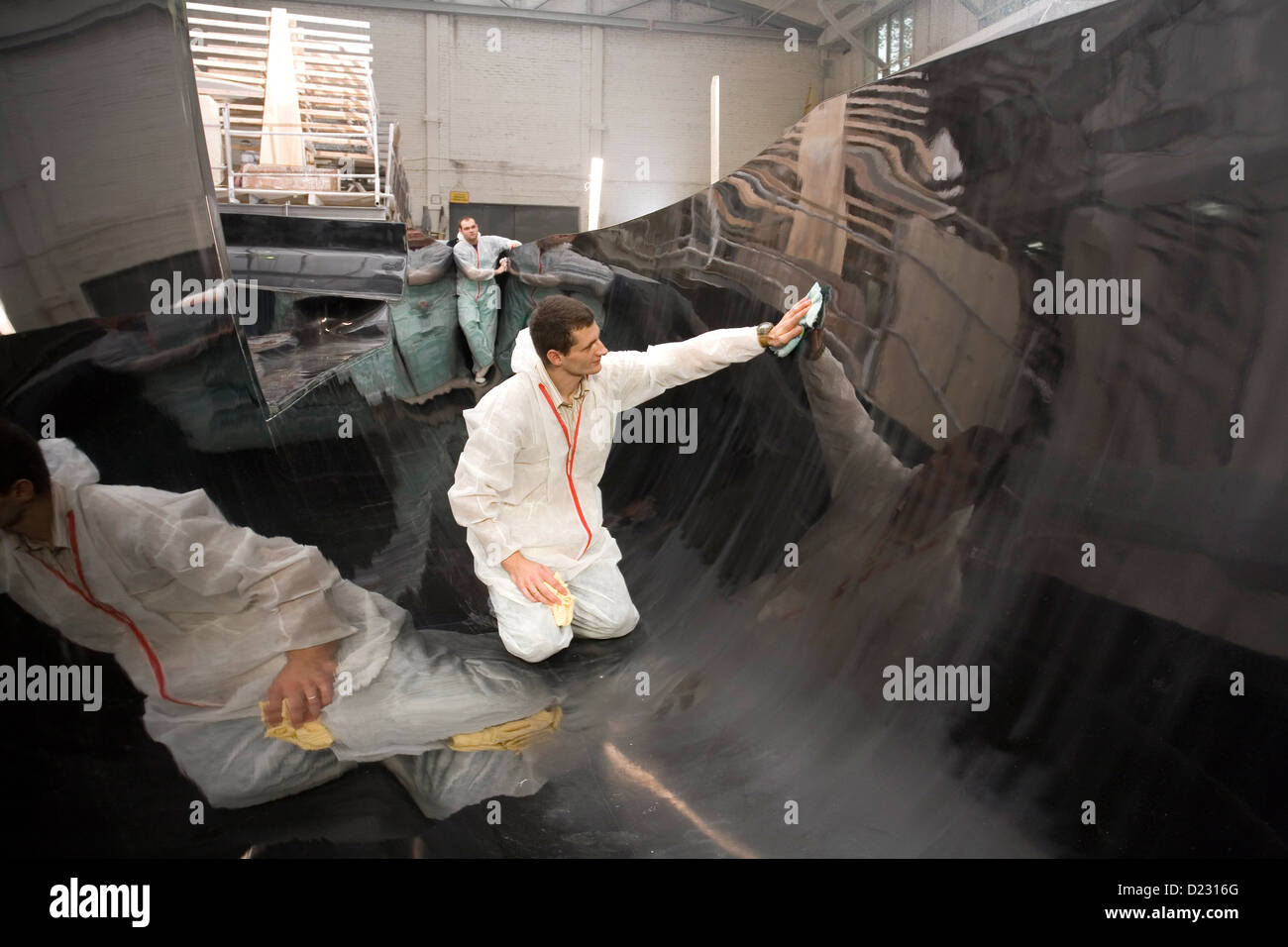 Szczecin, Poland, workers polish the hull of a catamaran under ...