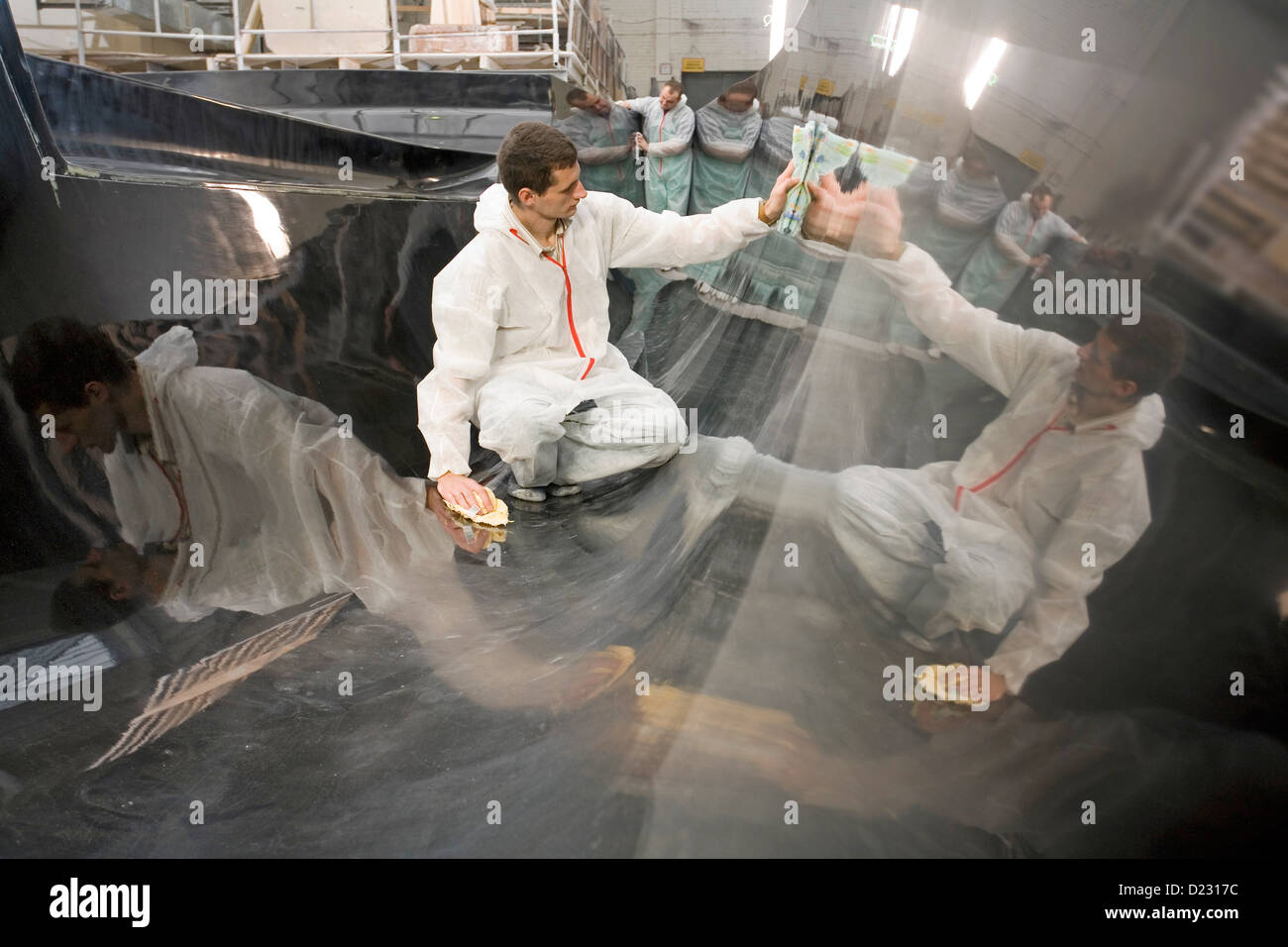 Szczecin, Poland, workers polish the hull of a catamaran under ...