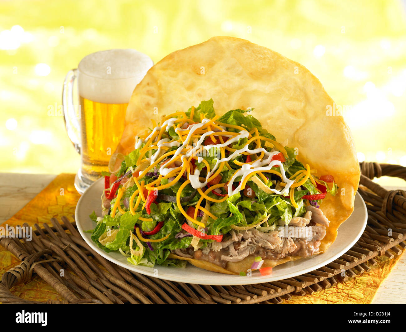 Chicken Tostada in a tortilla shell with a beer Stock Photo - Alamy
