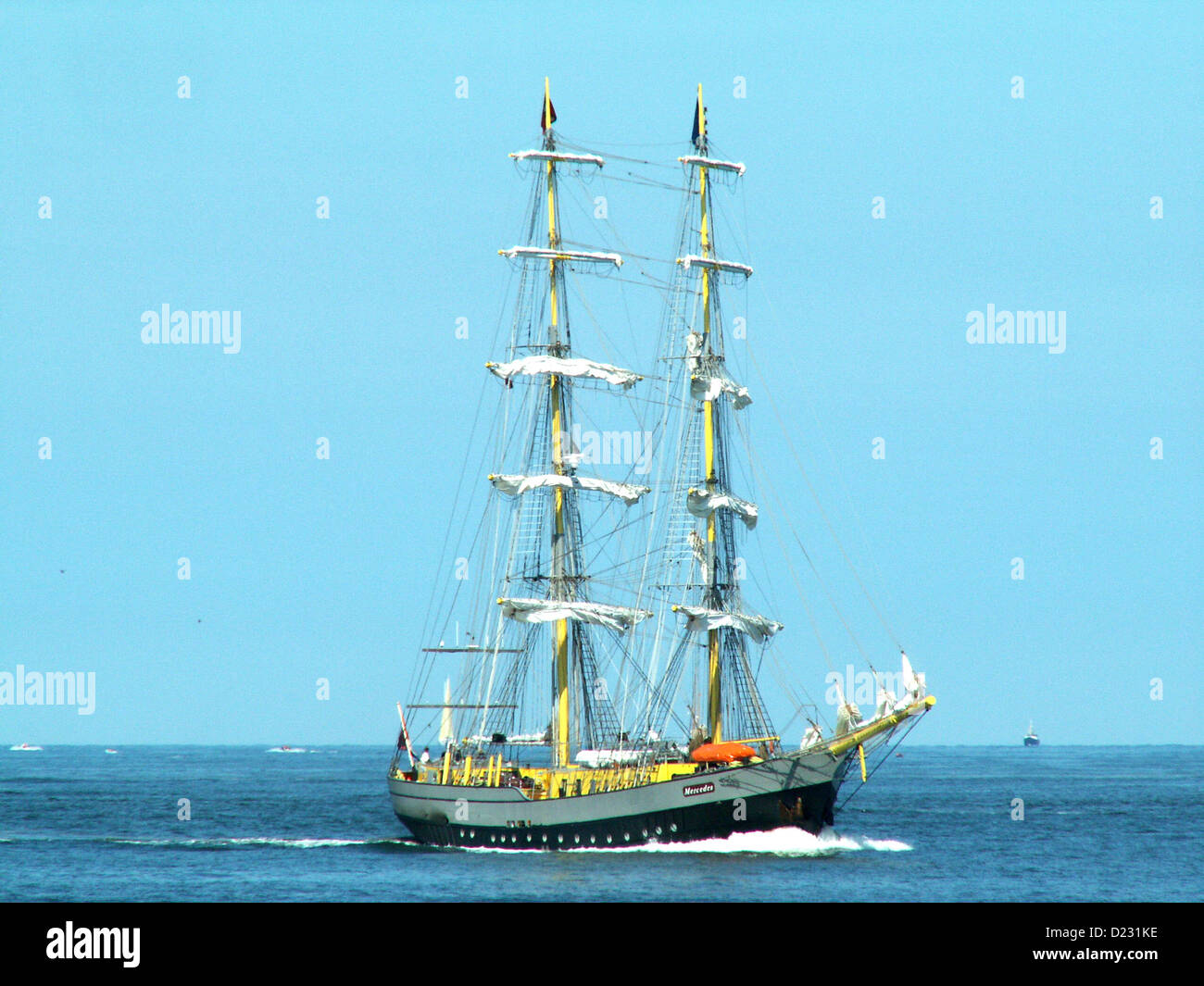 A classic Mercedes clipper ship, anchored in a calm ocean breeze, is a ...