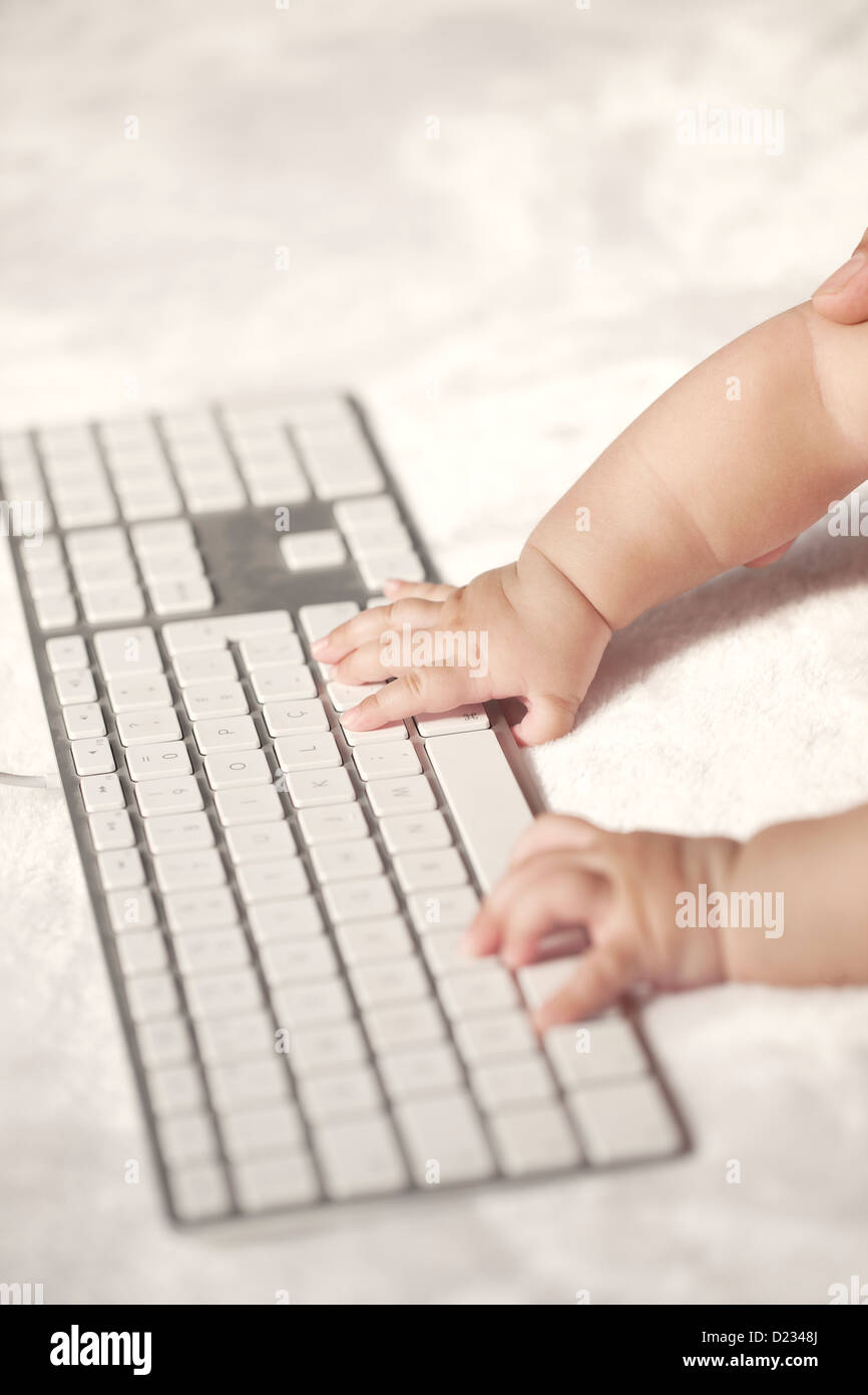 Baby touching computer keyboard Stock Photo - Alamy