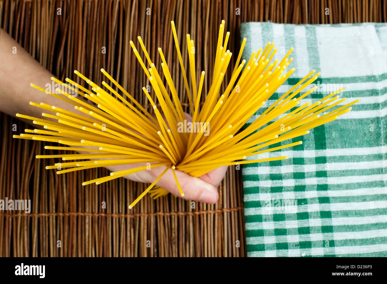 Female hand holding spaghetti. Green background Stock Photo - Alamy