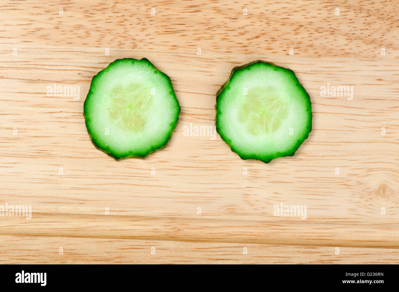 Two cucumber slices on wood Stock Photo - Alamy