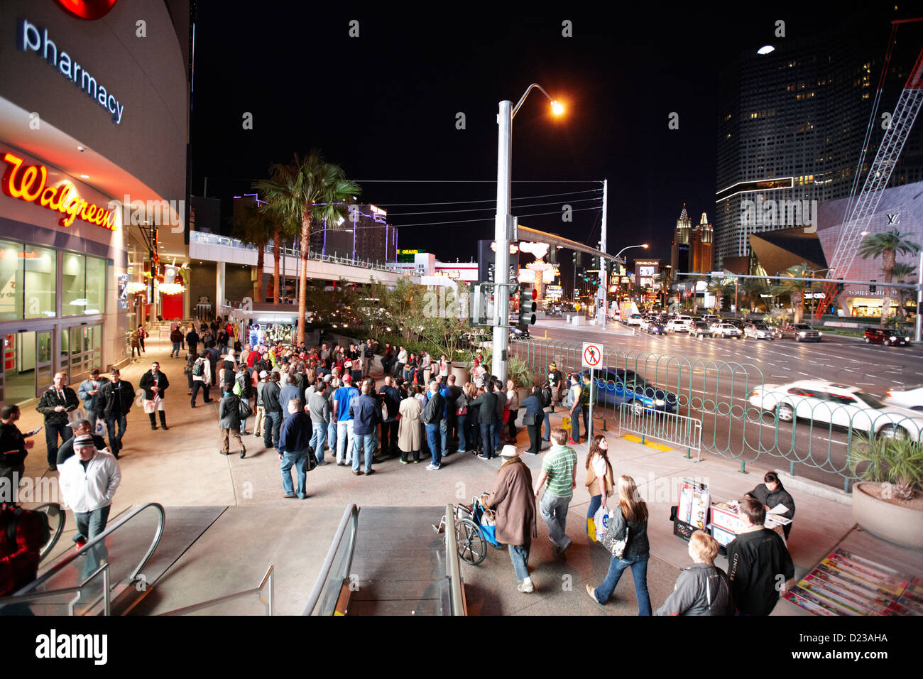 going down escalator to crowd around street entertainer at night las ...