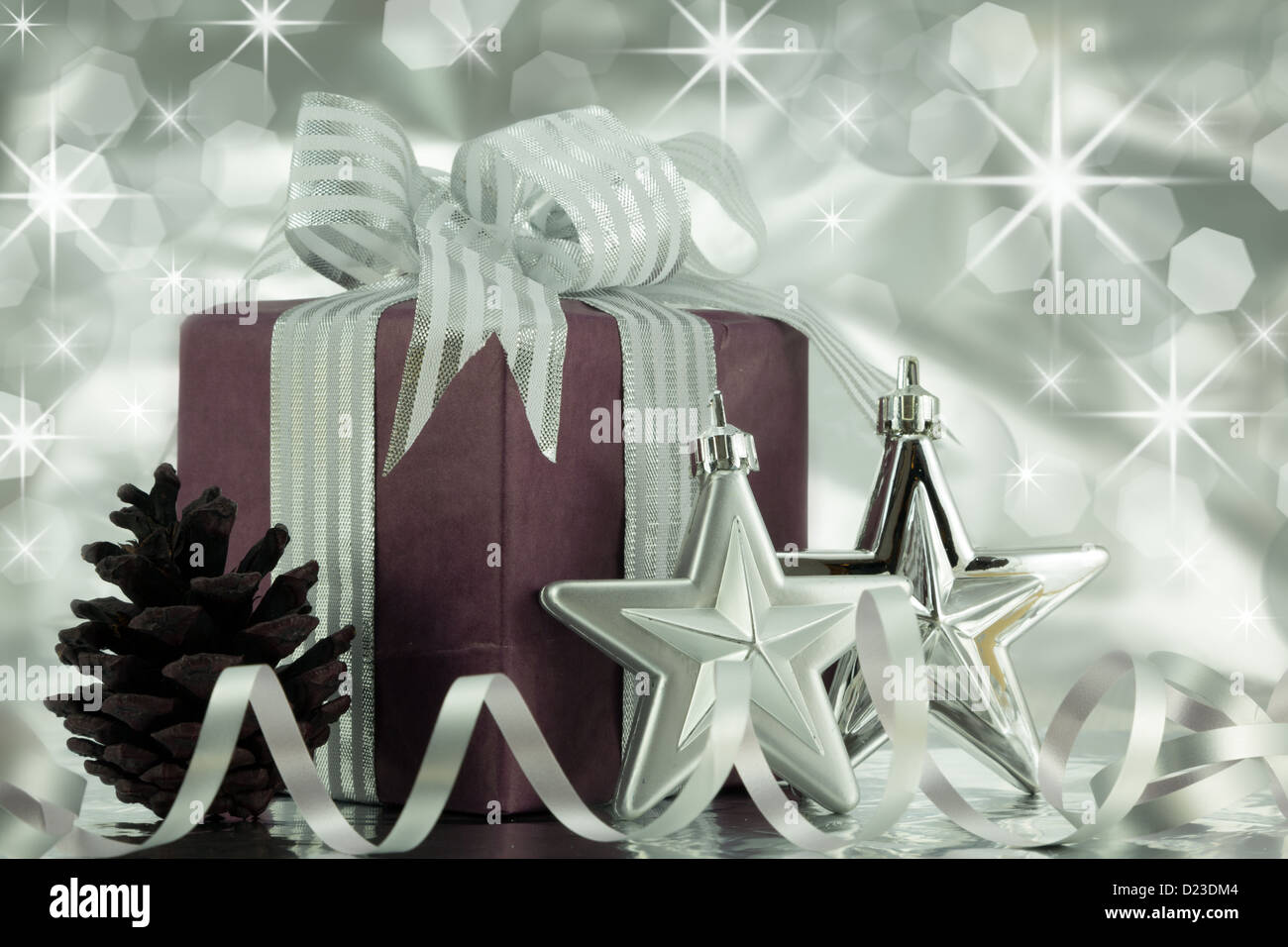 Wrapped present with silver stars,pine cone and diffused sparkle ...