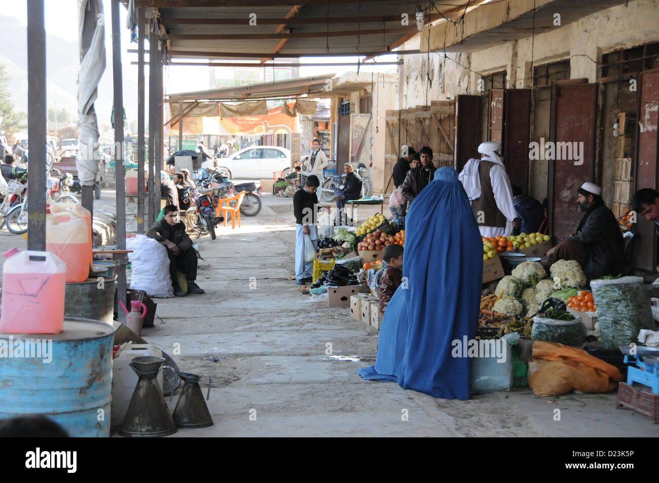 An Afghan woman, right, buys produce at a Farah City market, Jan. 13 ...