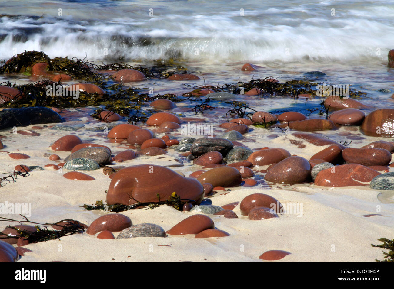 Pebbles, seaweed and breaking waves photographed on a beach in the West ...