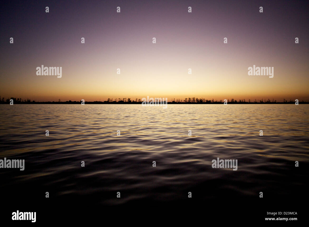Louisiana Delta at dusk with rippling water under a fading gradient sky ...