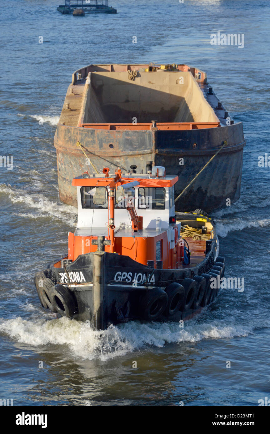 tug boat towing an empty barge on the River Thames in the Pool of ...
