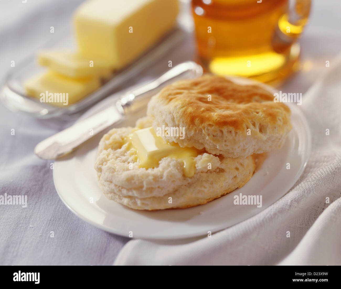 Biscuit on a white plate with melted butter and honey Stock Photo - Alamy