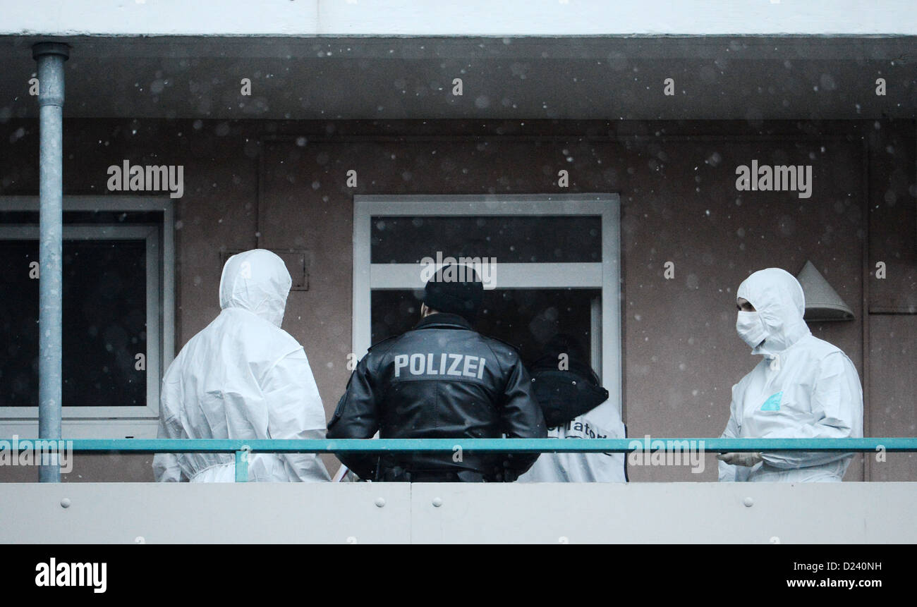 Forensics experts of the police stand in front of the entrance of an ...