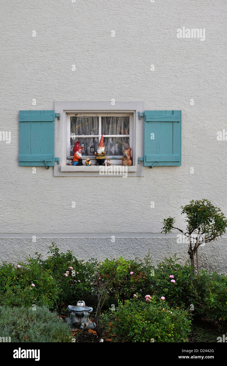 Germany, Baden Wuerttemberg, Window with shutter and garden gnomes ...