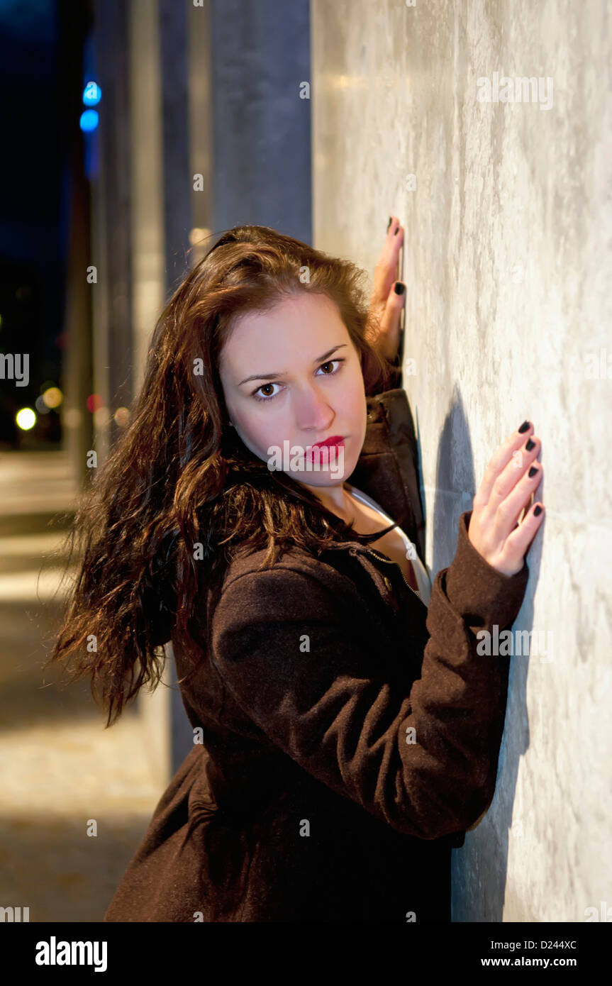 Germany, Young woman leaning against wall, portrait Stock Photo - Alamy