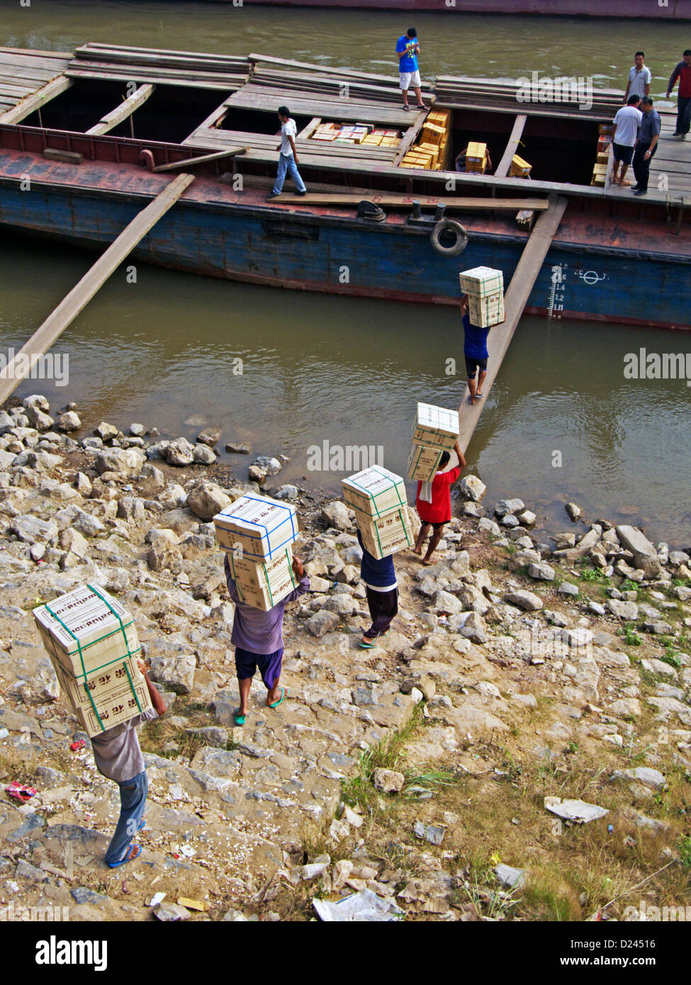 Laborers loading China bound boat at dock in Chiang Saen, Thailand ...