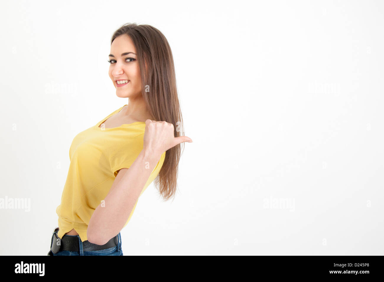 Portrait of young woman pointing backwards with her thumb Stock Photo ...
