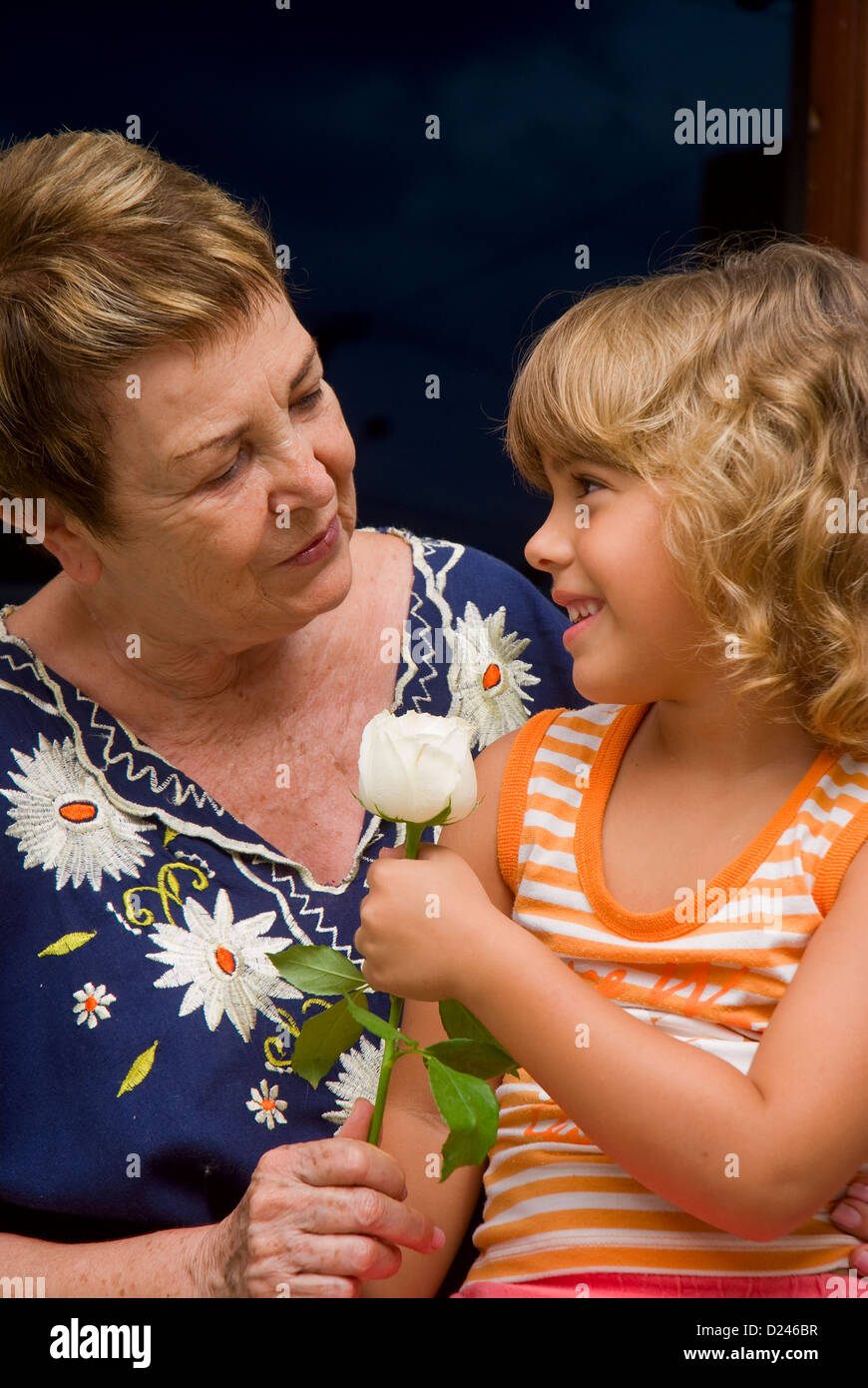 girl offering a rose to grandmother Stock Photo - Alamy