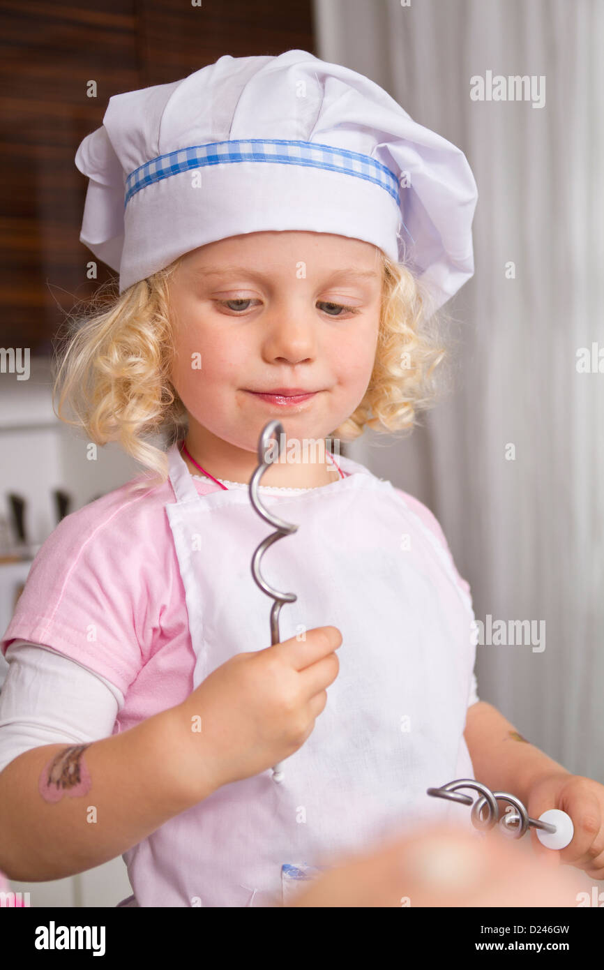 Germany, Eggersdorf, Girl with cook hat holding mixer curls Stock Photo ...