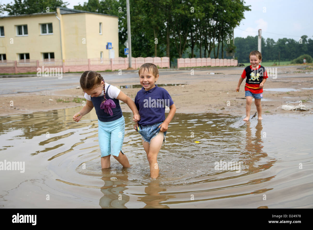Children playing in water puddle hi-res stock photography and images ...