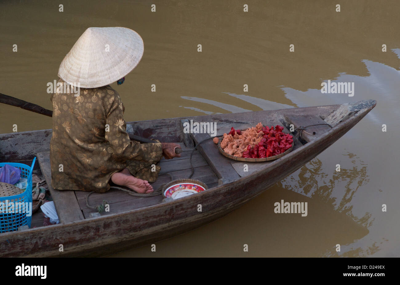 A lady vendor rows her small fishing boat along the Thu Bon River in ...