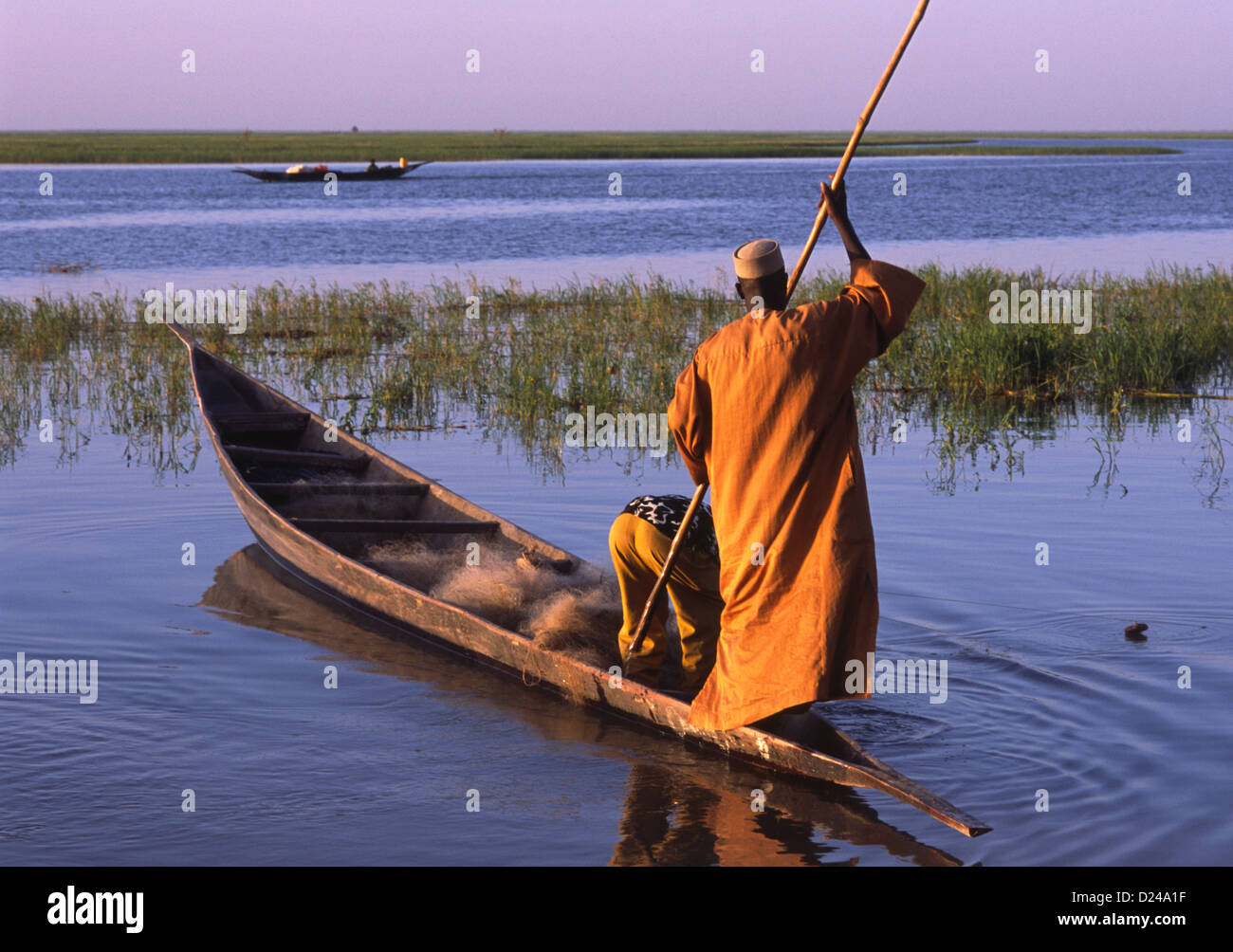 A Bozo fisherman on his pirogue in Mali, West Africa. Bozo are one of ...