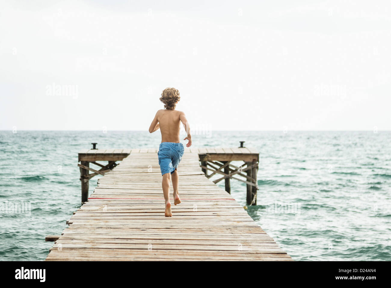 Three children running into sea hi-res stock photography and images - Alamy