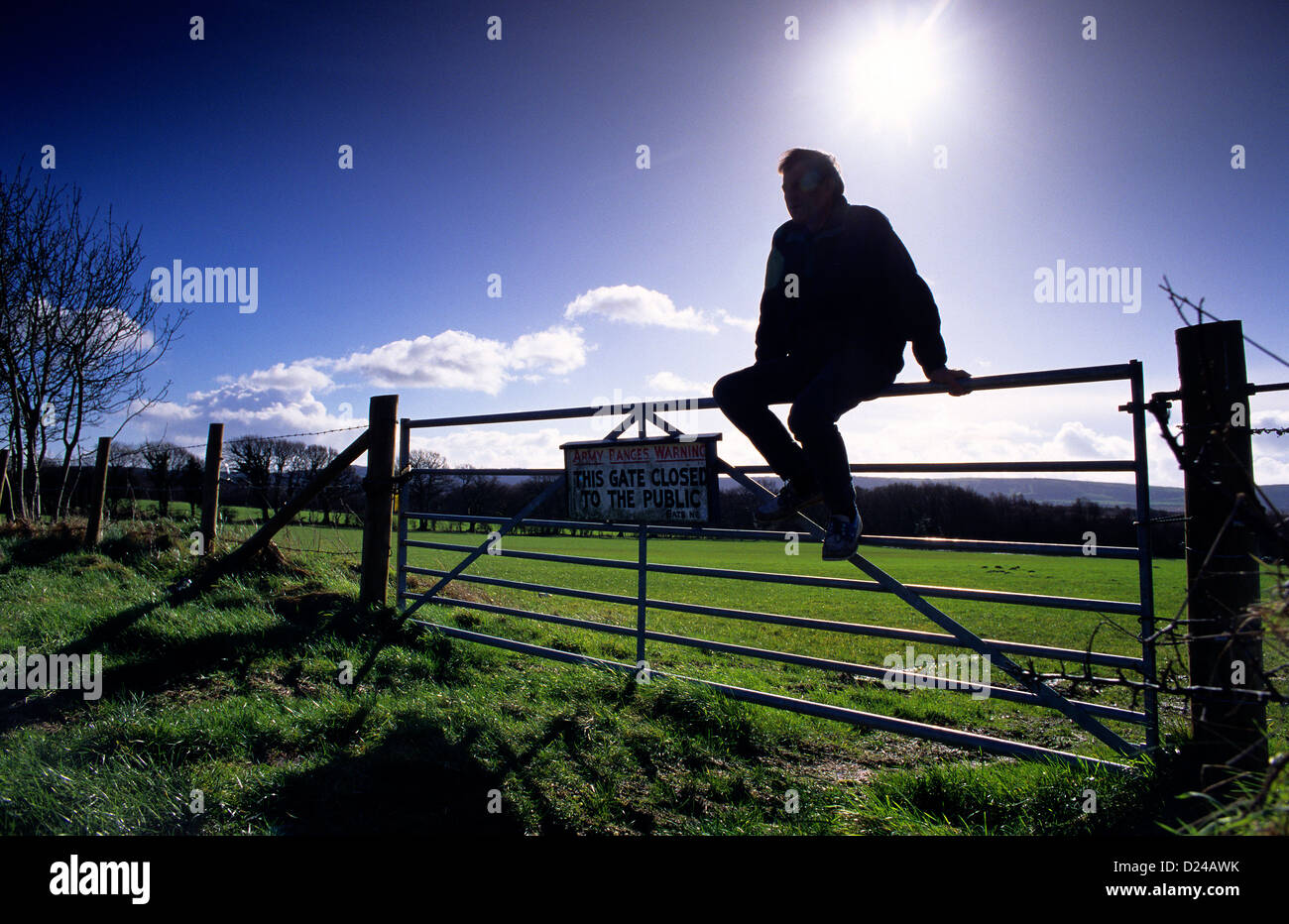 Person sitting on a gate by a field near the village of Tyneham in ...