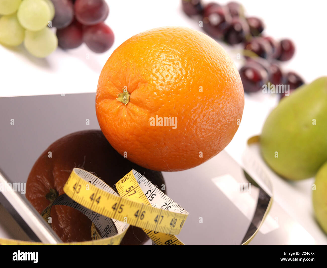 Orange on a scale with fresh fruits Stock Photo - Alamy