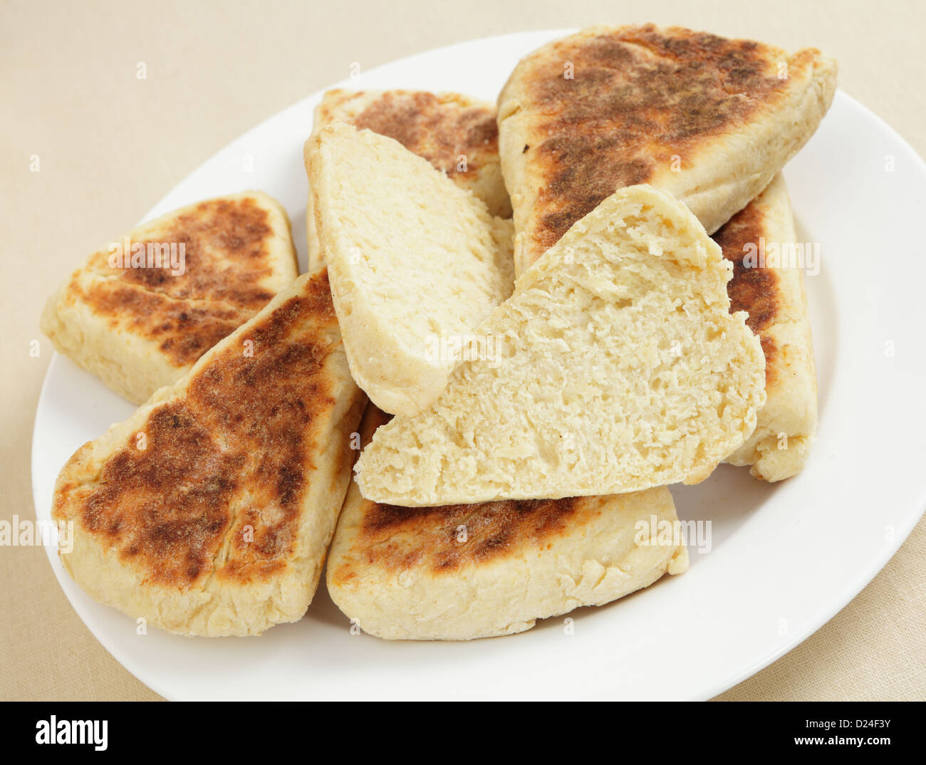 Scottish girdle scones on a plate, with one of them sliced in half to ...