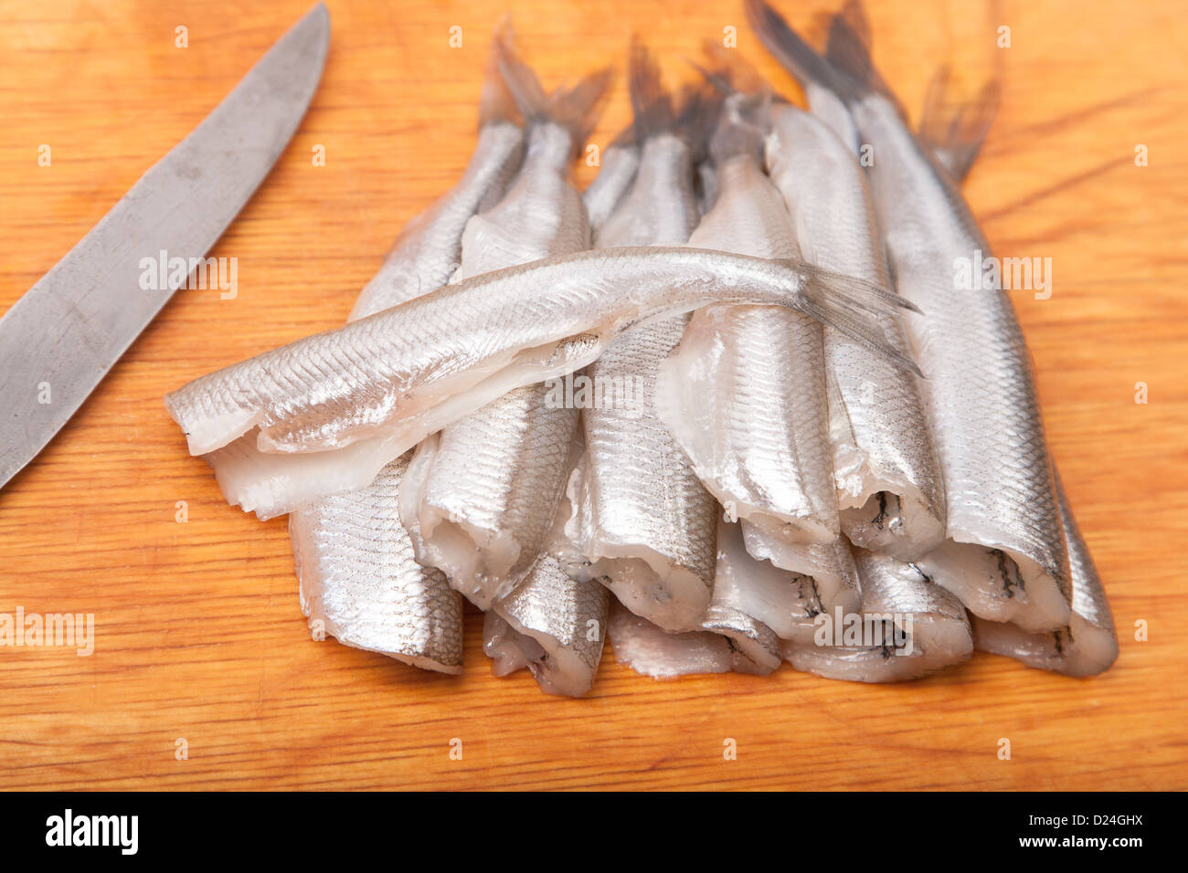 many uncooked trunk small fish on wood board Stock Photo - Alamy