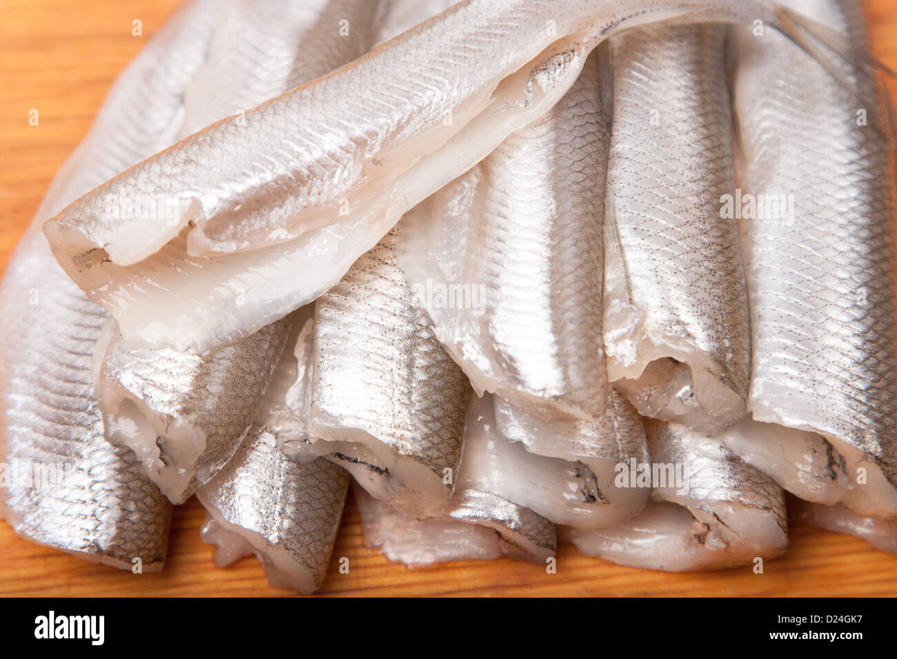 many uncooked trunk small fish on wood board Stock Photo - Alamy