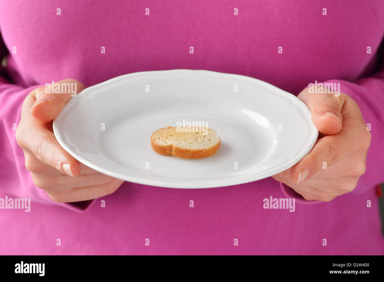 One small toast on the white plate. Small portion of food. Conceptual ...