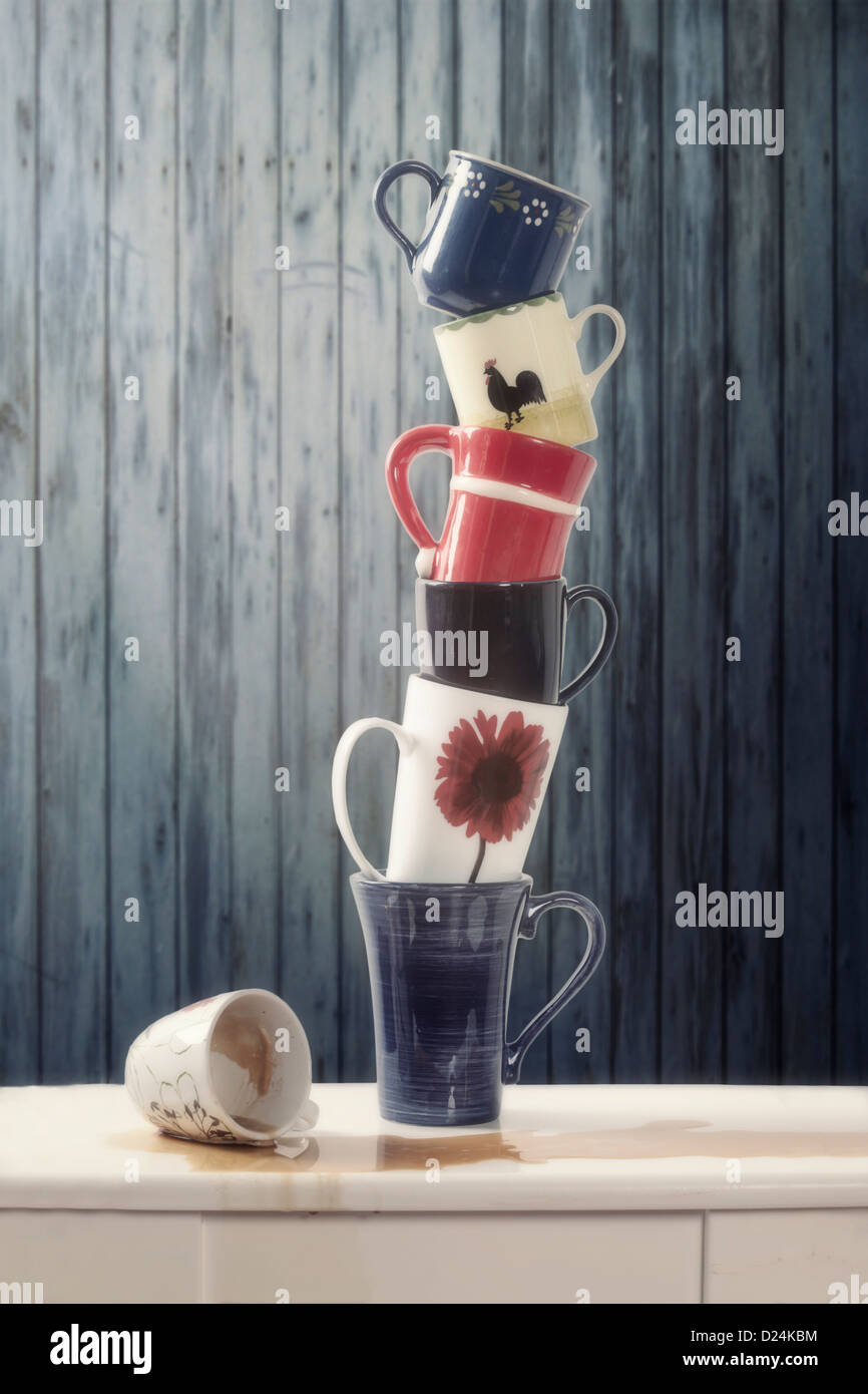 a stack of balanced cups, one cup spilled coffee Stock Photo - Alamy