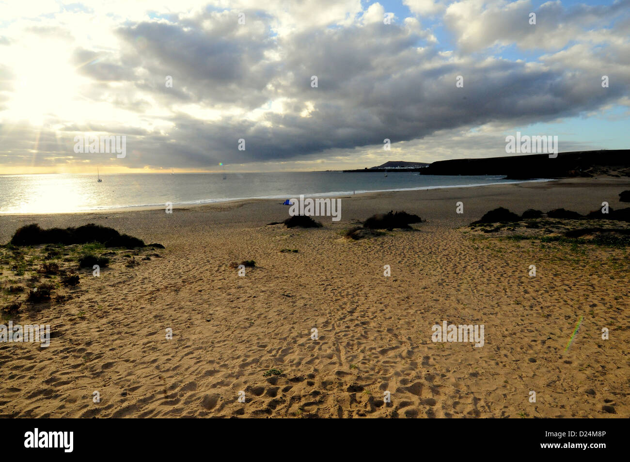 Beach scene with sun reflecting off the sea Stock Photo - Alamy