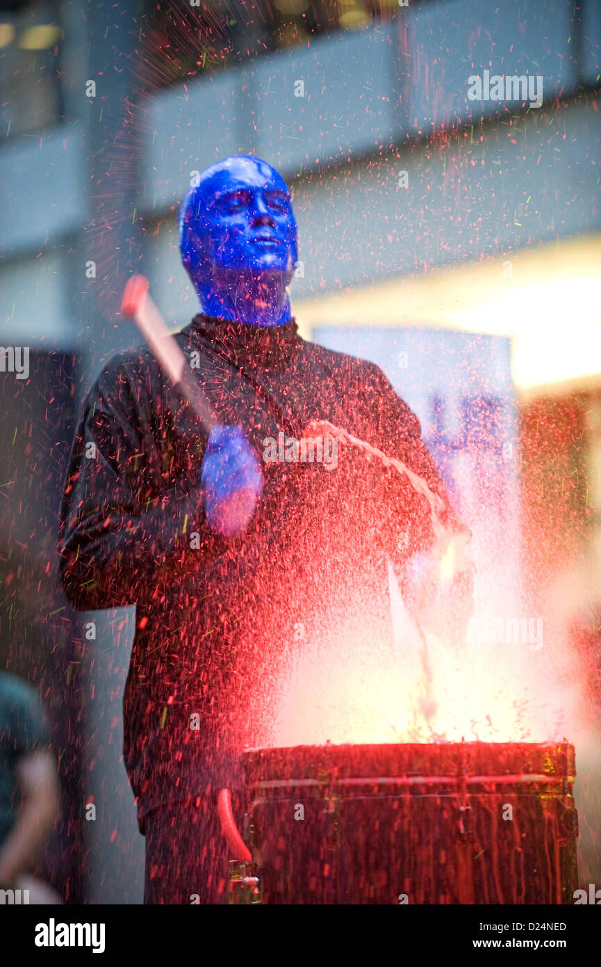 Berlin, Germany, a Blue Man drums and splashed red paint Stock Photo ...