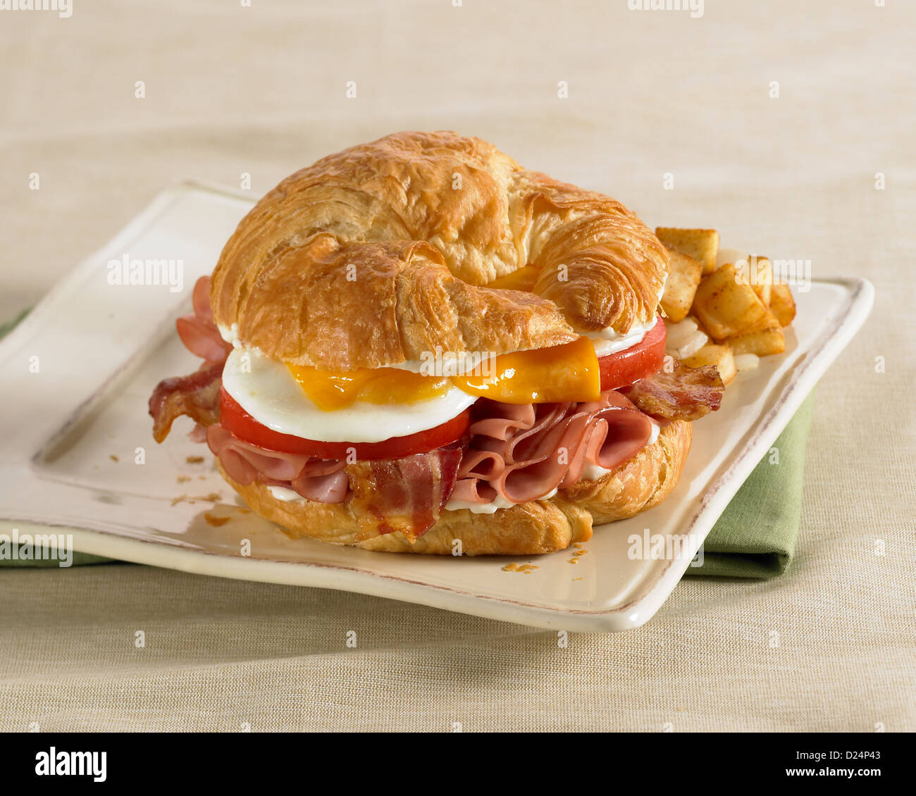 Breakfast croissant sandwich with eggs, bacon, ham and cheese Stock ...