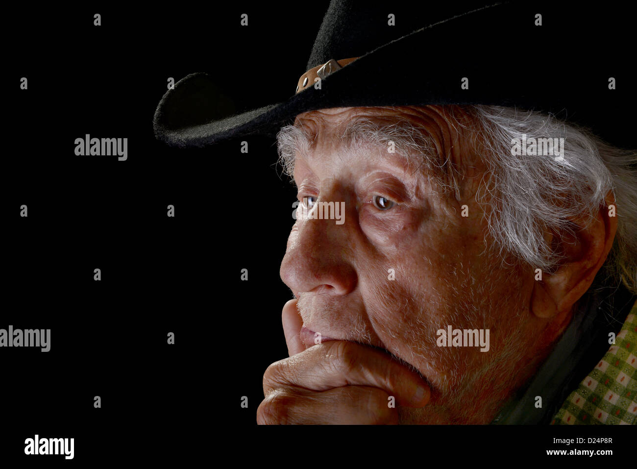 Old man with serious look on face wearing a black cowboy hat isolated ...