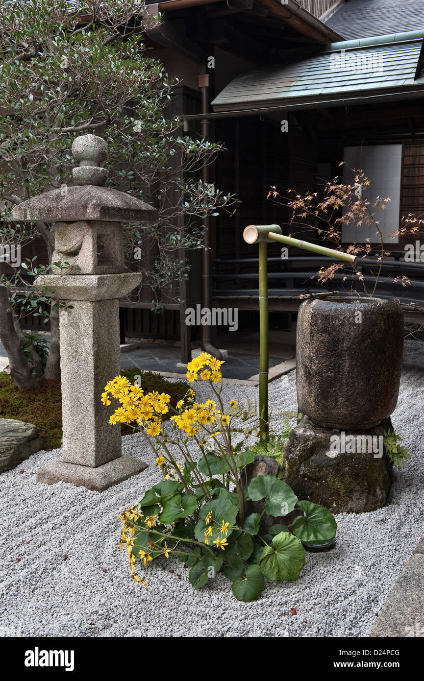 A Japanese stone lantern (tōrō) and a tsukubai or water basin for ...