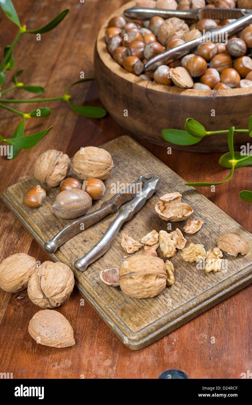 Edible nuts and nutcrackers on a table at home with mistletoe in a ...