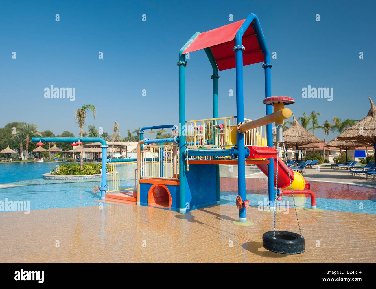 Climbing frame and slide in children's play area of a shallow swimming ...
