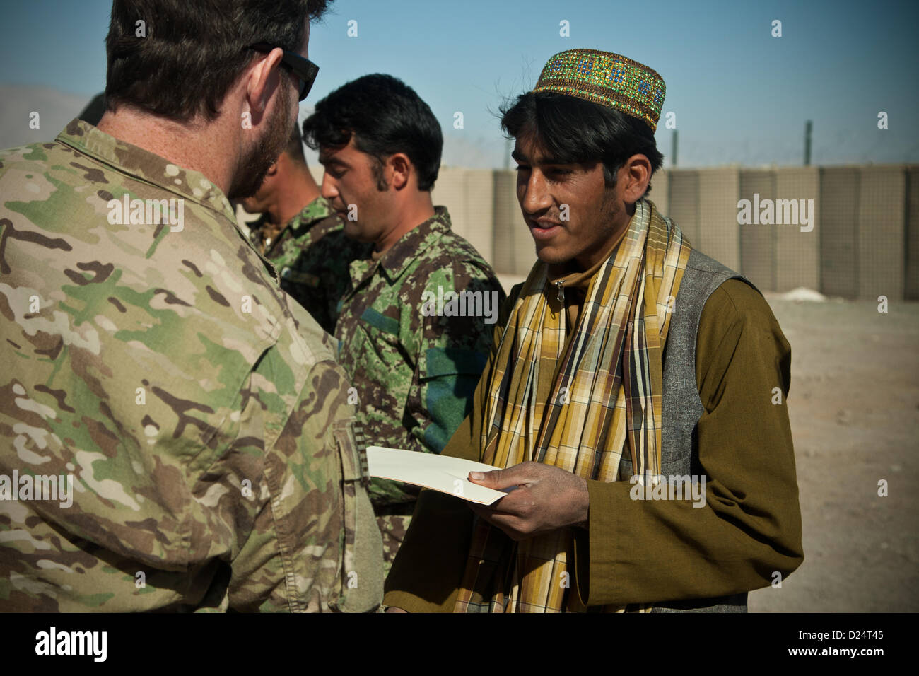 A coalition force member presents an Afghan Local Policeman with a ...