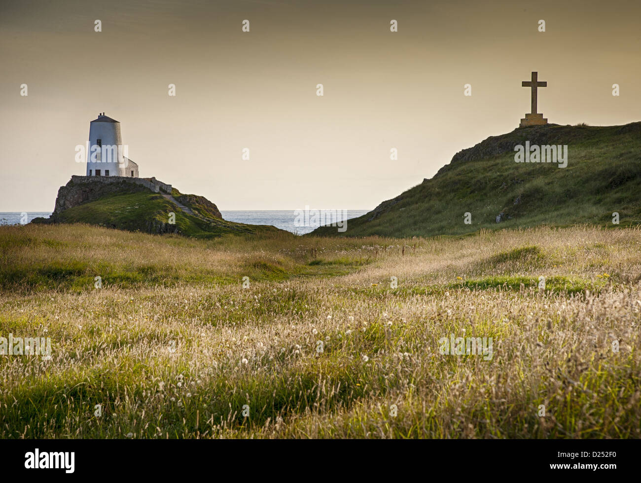 View lighthouse cross coastline on tidal island Llanddwyn Island ...