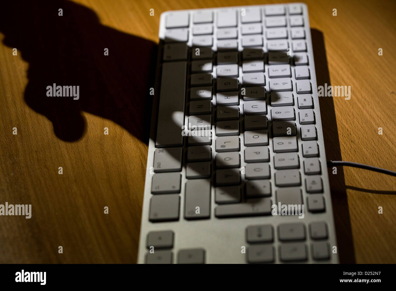Shadow of a hand over a computer keyboard Stock Photo - Alamy