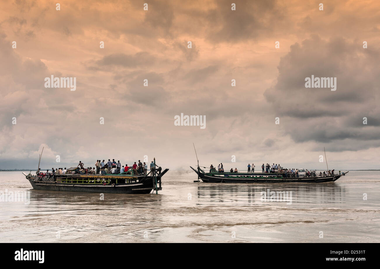 Two public ferry boats cross the river Brahmaputra at sunset on their ...