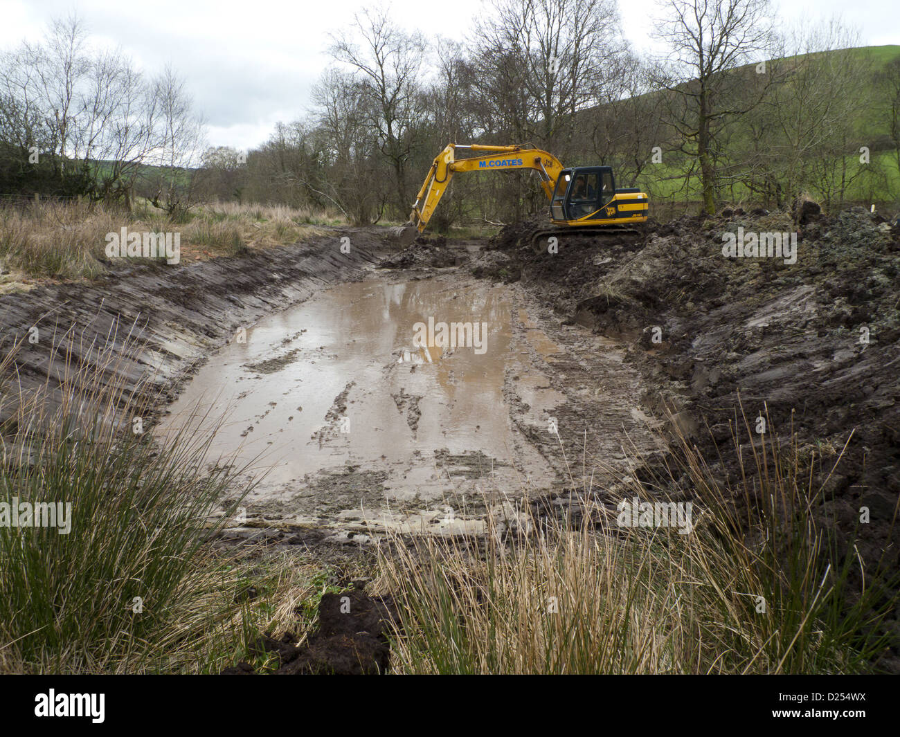 Contractor with 360degree excavator, digging wildlife pond on farm ...