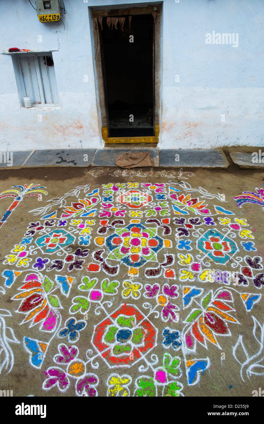 Rangoli coloured powder design in a rural Indian village street during ...